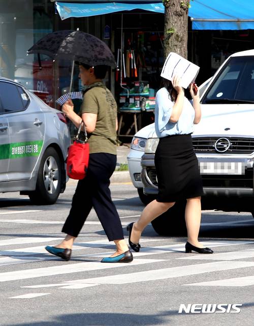 자외선 차단하며 걷는 여성들