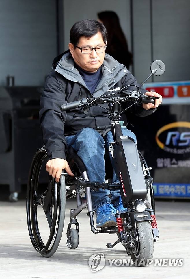 휠체어 전동보조키트 시연하는 업체 관계자